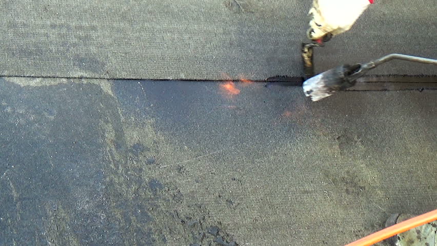 Stock Video Clip of Worker performs sealing overlapping bitumen sheets ...