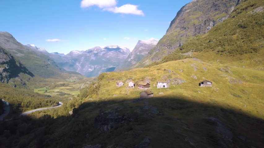 Landscape with houses, hills, and mountains in the distance image ...
