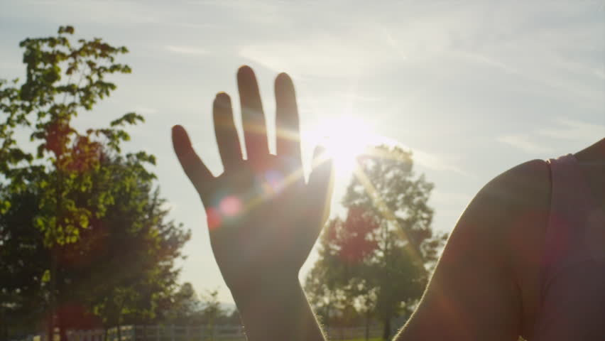 SLOW MOTION CLOSE UP: Woman Waving Goodbye, Sun Shining Through The ...