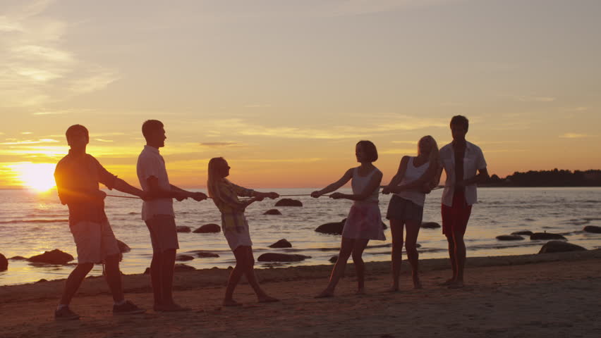Four Friends Jumping On The Beach At Sunset Silhouetted Stock Footage ...