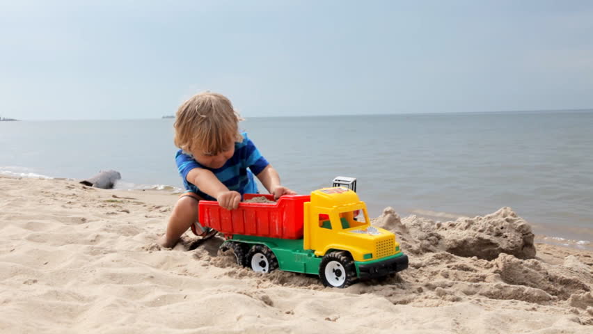 Little Kid Playing With Toy Tractor On The Beach Stock Footage Video ...