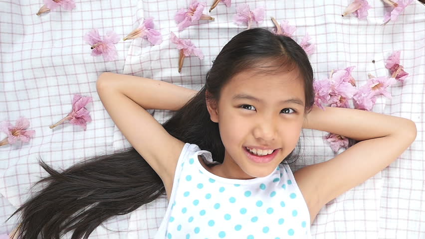 Little Asian Child Laying Down On The Floor With Falling Flowers, Slow ...