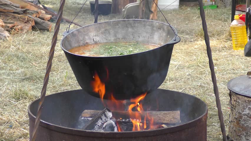 Stock video of cooking outdoors in cast-iron cauldron. cooking ...
