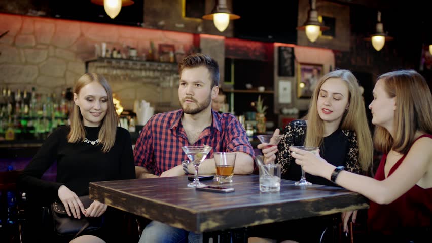 Happy Young People Sitting In The Bar Reading Menu Card And Giving ...