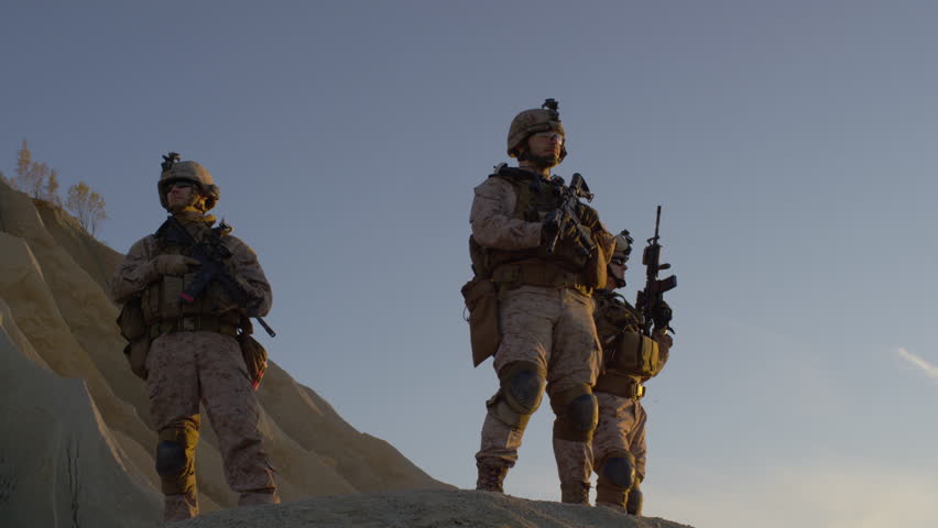 Squad Of Three Fully Equipped And Armed Soldiers Standing On Hill In ...