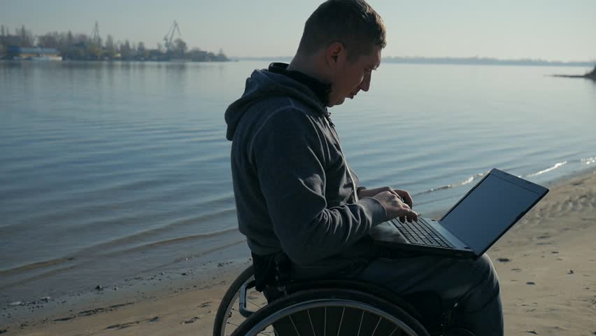 Lonely Disabled Woman Sits And Thinks In Her Wheelchair At The Water's ...