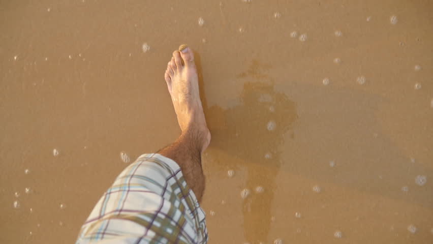 A Side View Of A Young Man Standing Barefoot On A Beautiful Sandy Beach ...