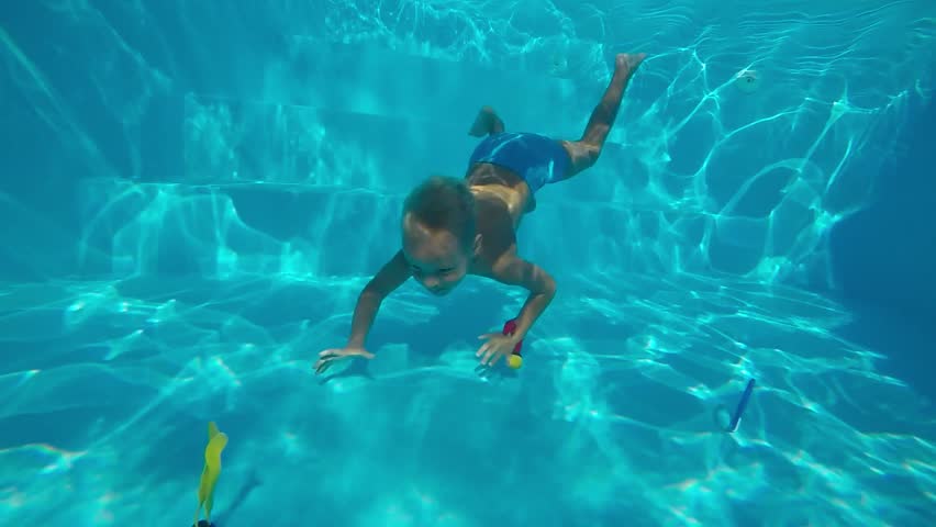 Children's Games In The Pool. A Little, Cute Boy Sinking In The Pool ...